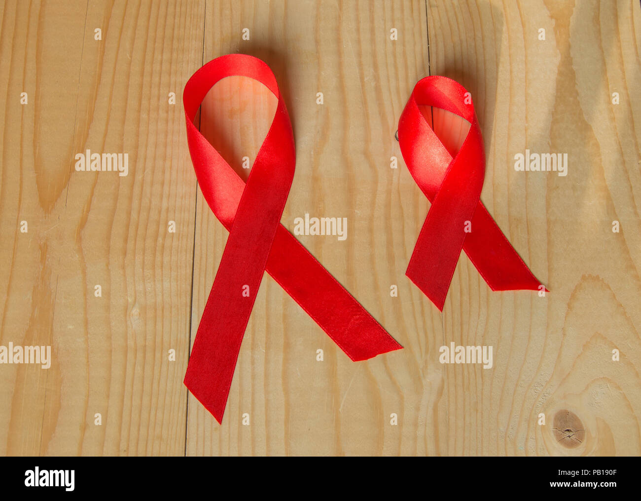 Awareness red ribbon on wood background: world day fight against AIDS ...