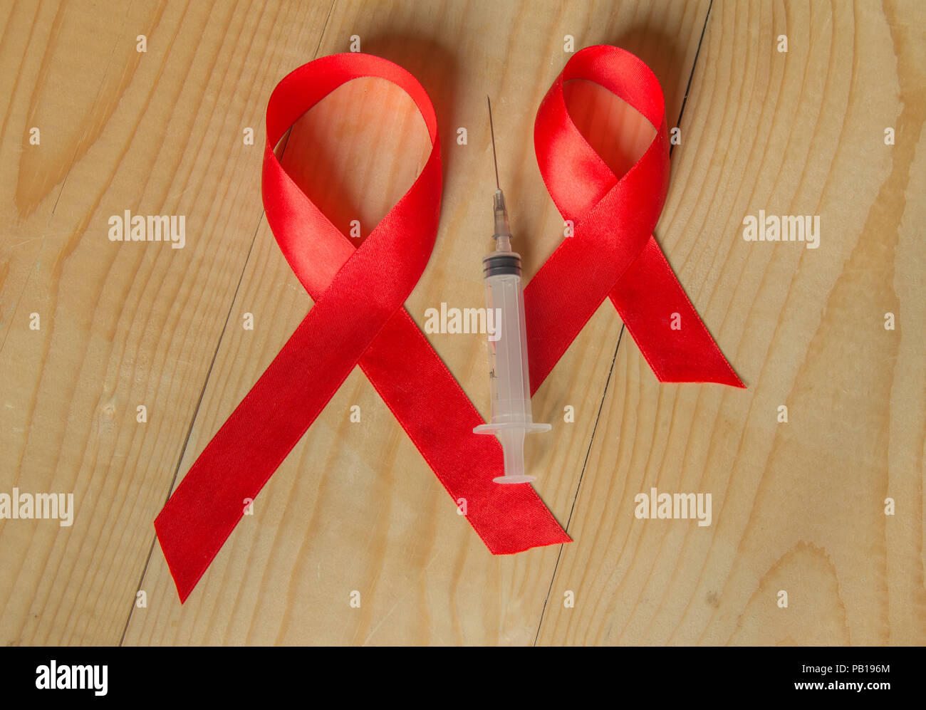 Awareness red ribbon and syringe on wooden background: world day of ...
