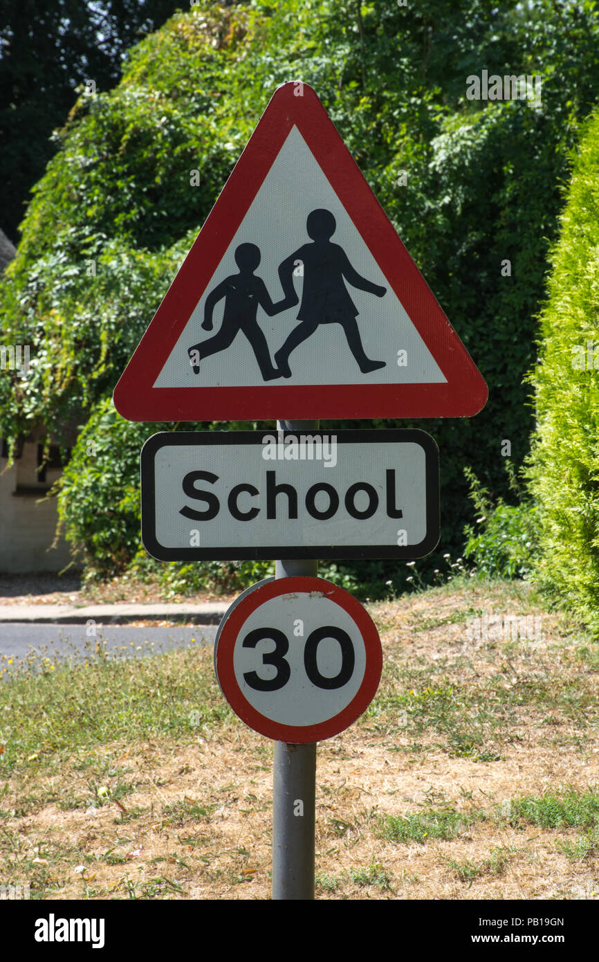 Road sign warning of a school, triangular sign with children, 30 mph ...