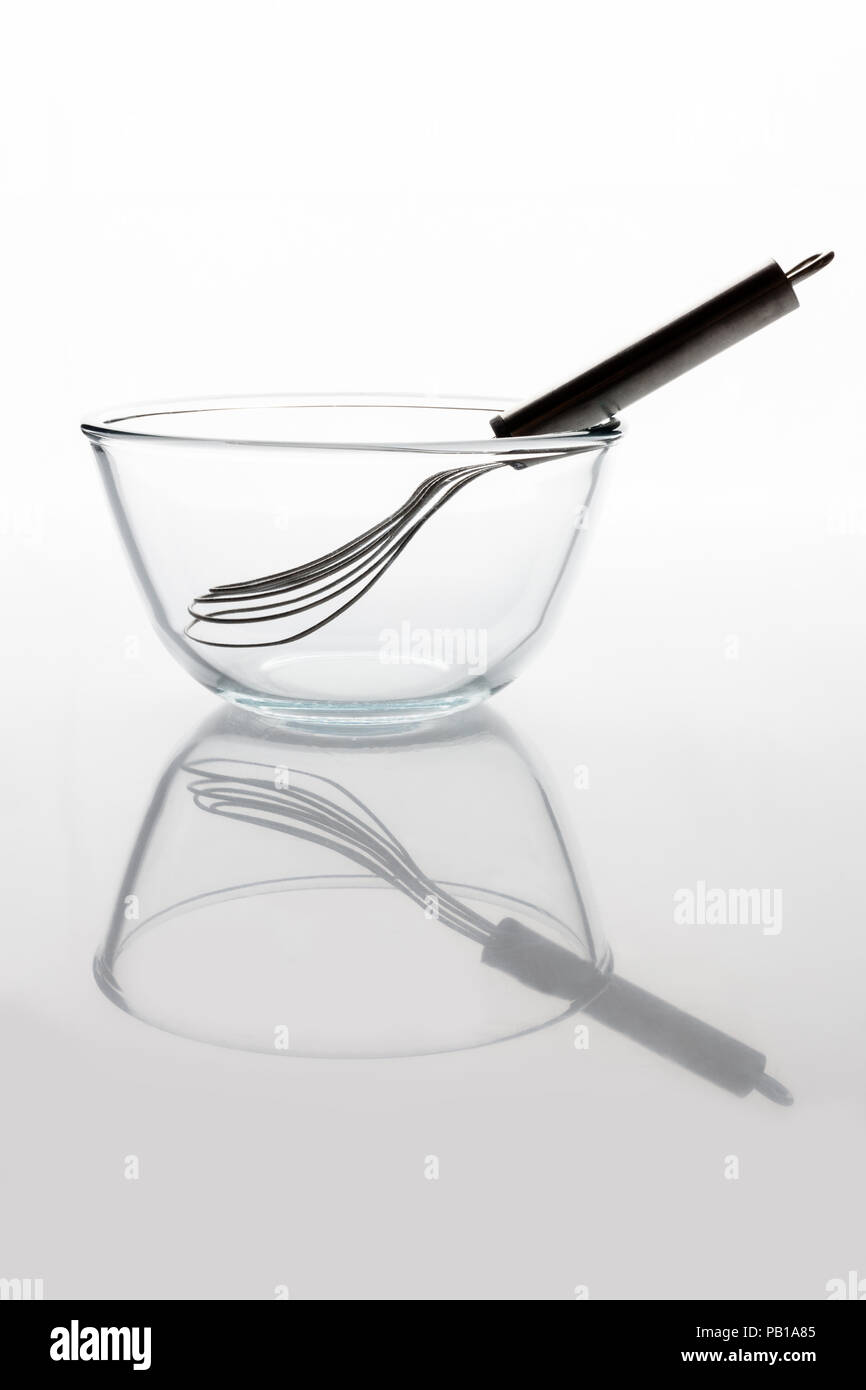 Glass transparent bowl with metal whisker inside on white background ...