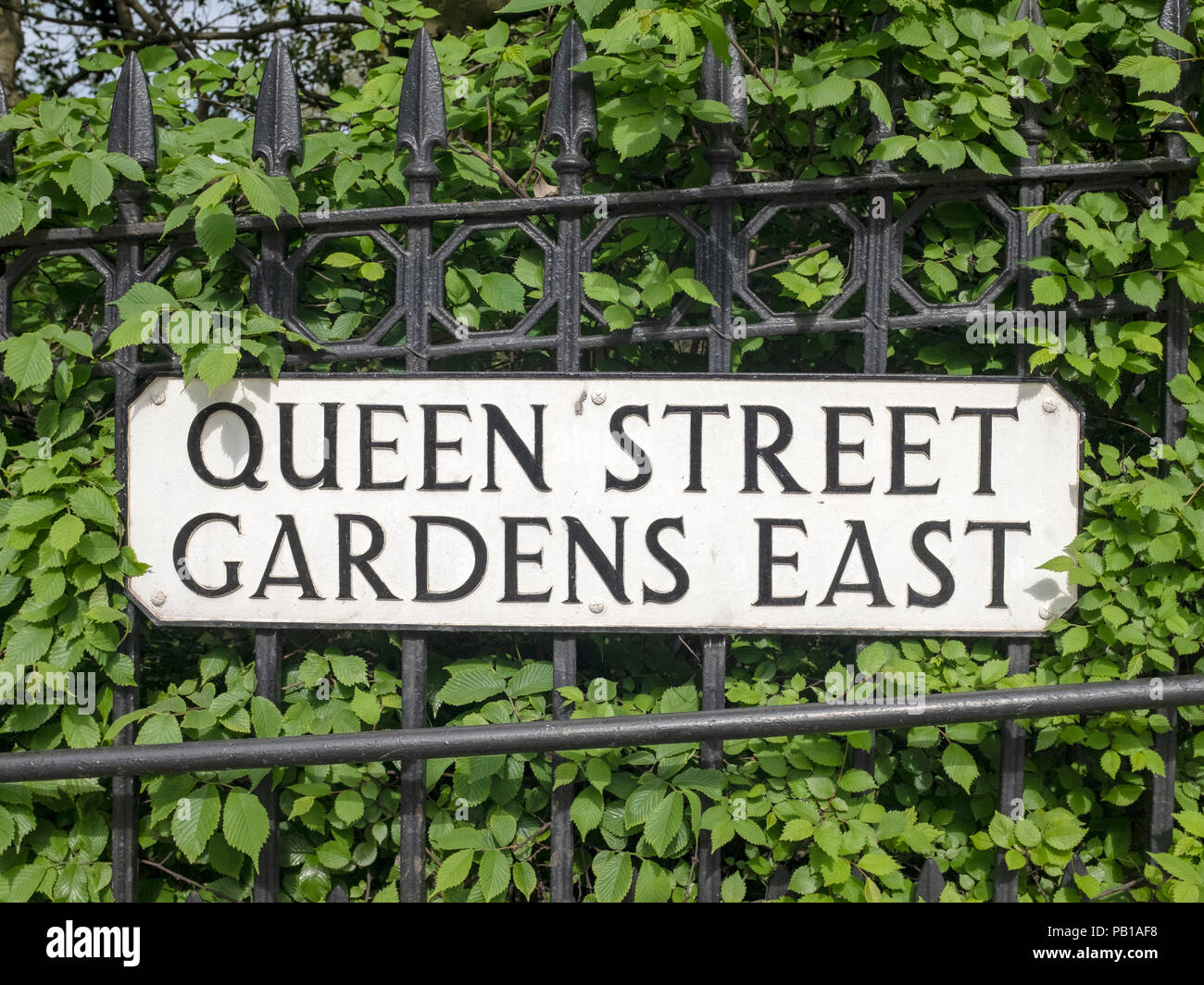 Queens Street Gardens East street sign with black railings and a hedge ...