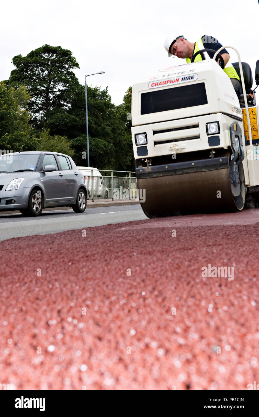 Laying red asphalt on a road in the UK Stock Photo - Alamy