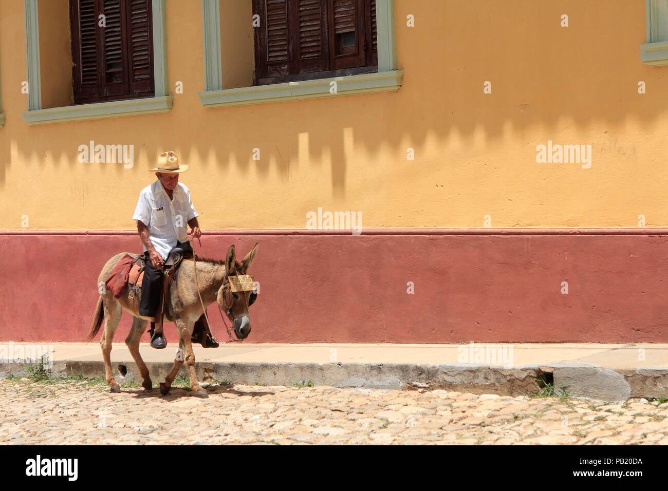 Old man riding his donkey into the town of Trinidad, Cuba Stock Photo ...