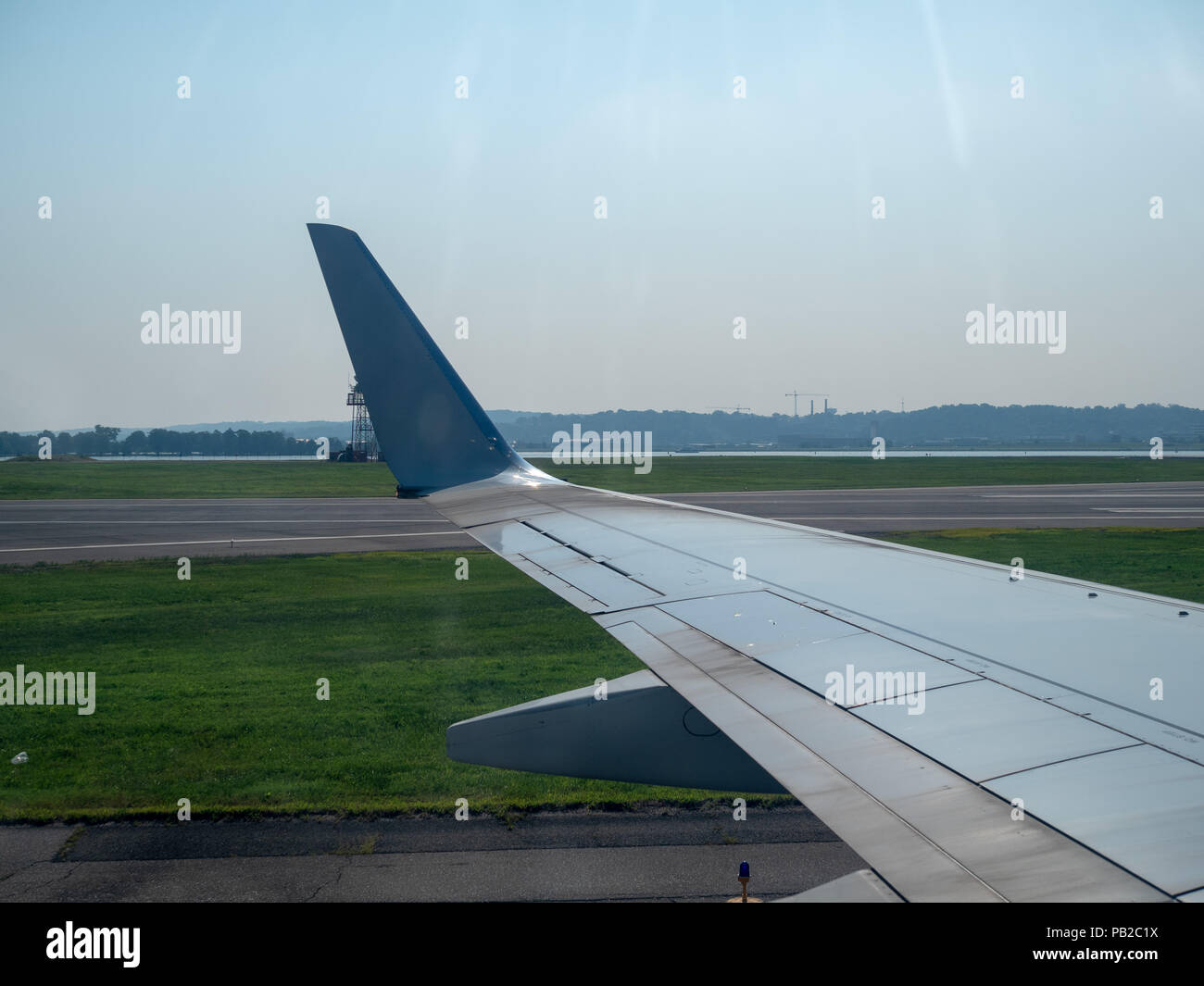 Wing of airplane in middle of takeoff on runway of airport Stock Photo ...