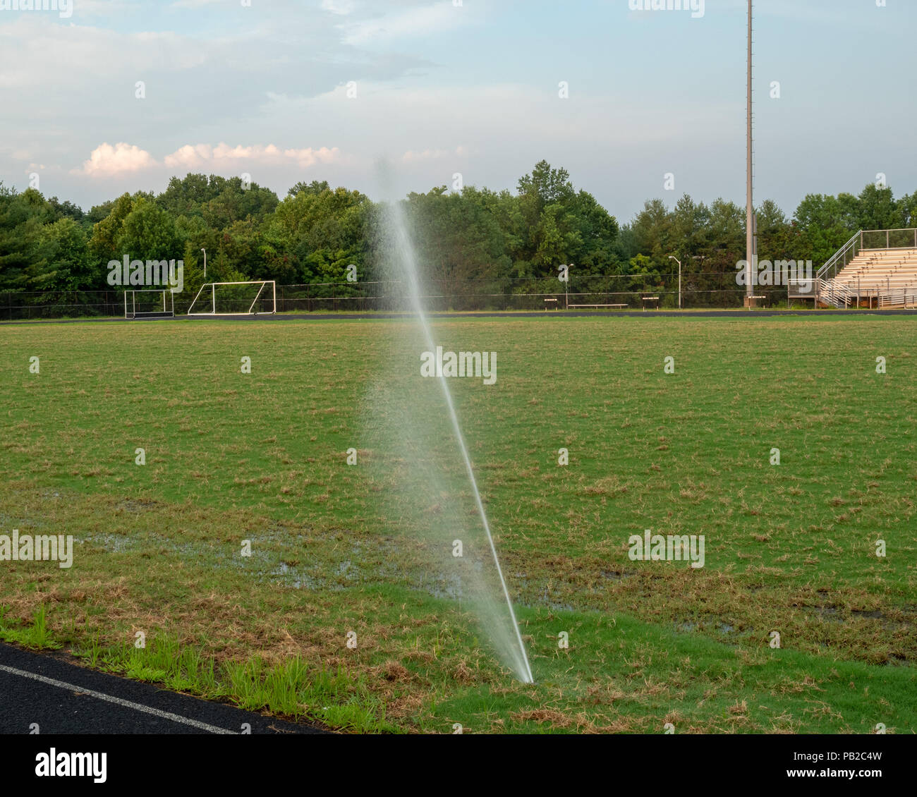 Sprinkler system tending to a run down, off-season field at a high ...