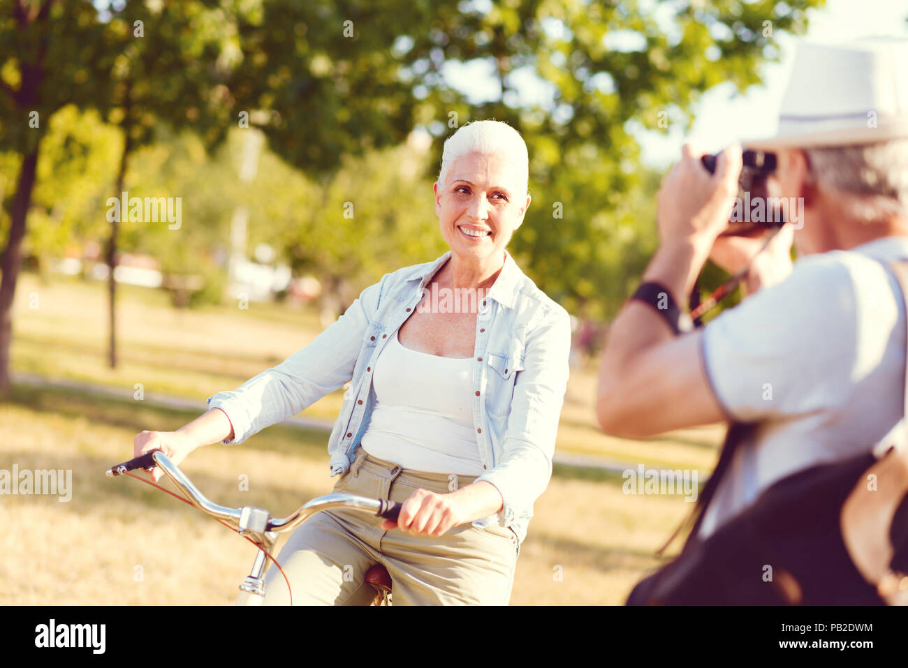 Beautiful retired lady posing for photo with bicycle Stock Photo - Alamy