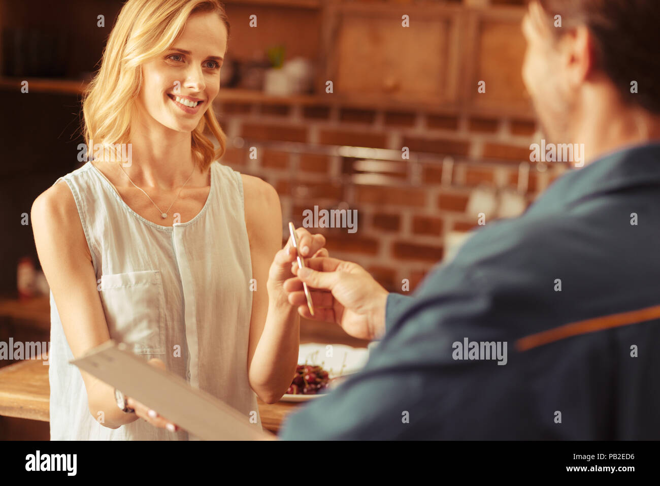 Charming female person taking pen Stock Photo - Alamy
