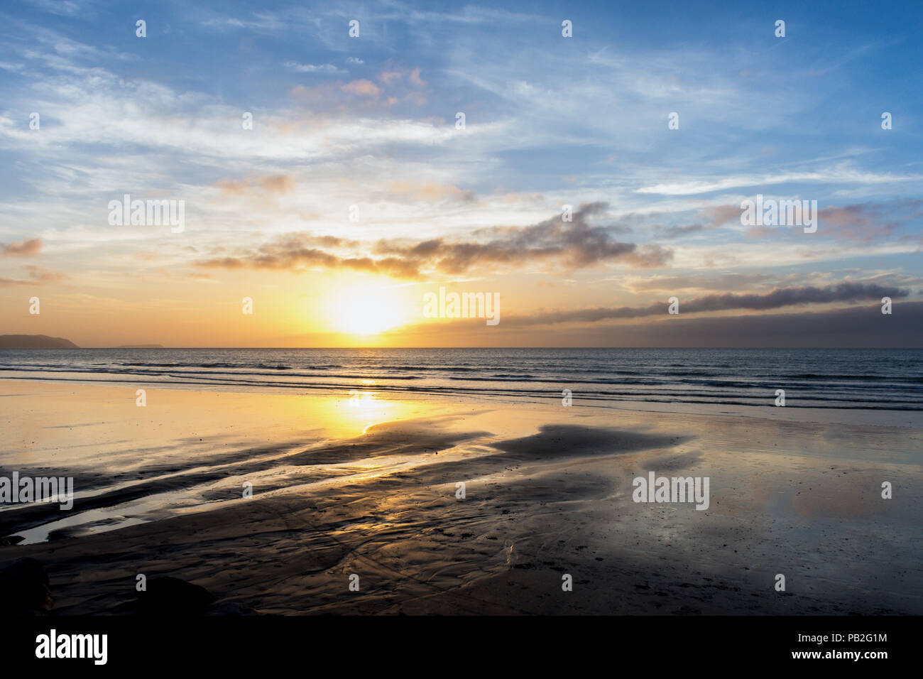 Sunset over the beach with reflection in wet sand at Raumati beach in ...