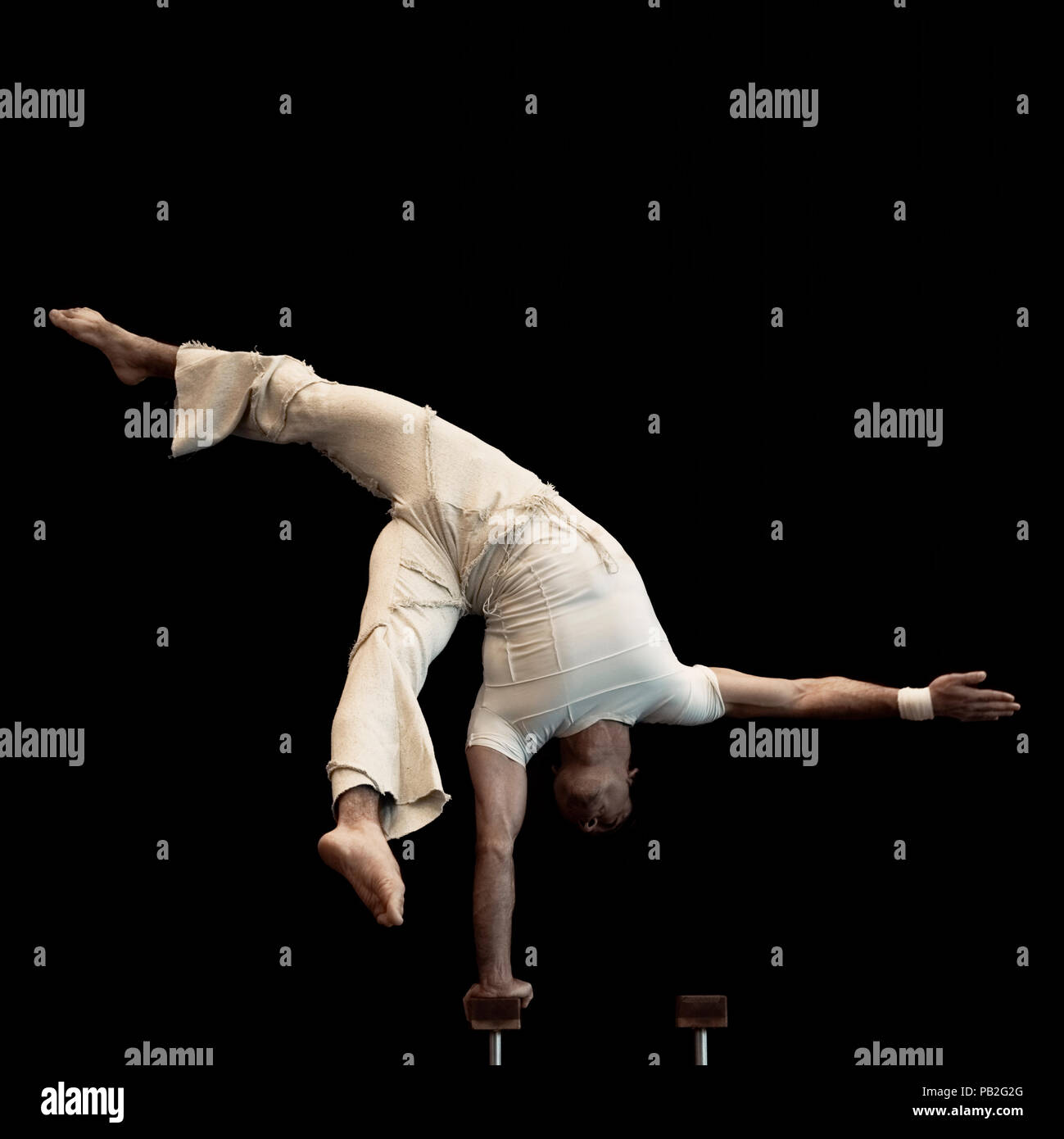 Circus performer balancing on one hand and creative very difficult ...