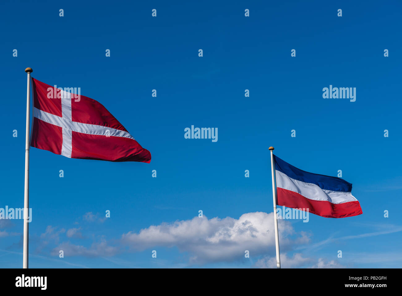 Danish and German flag, against the sky, windy day, Schleswig-Holstein ...