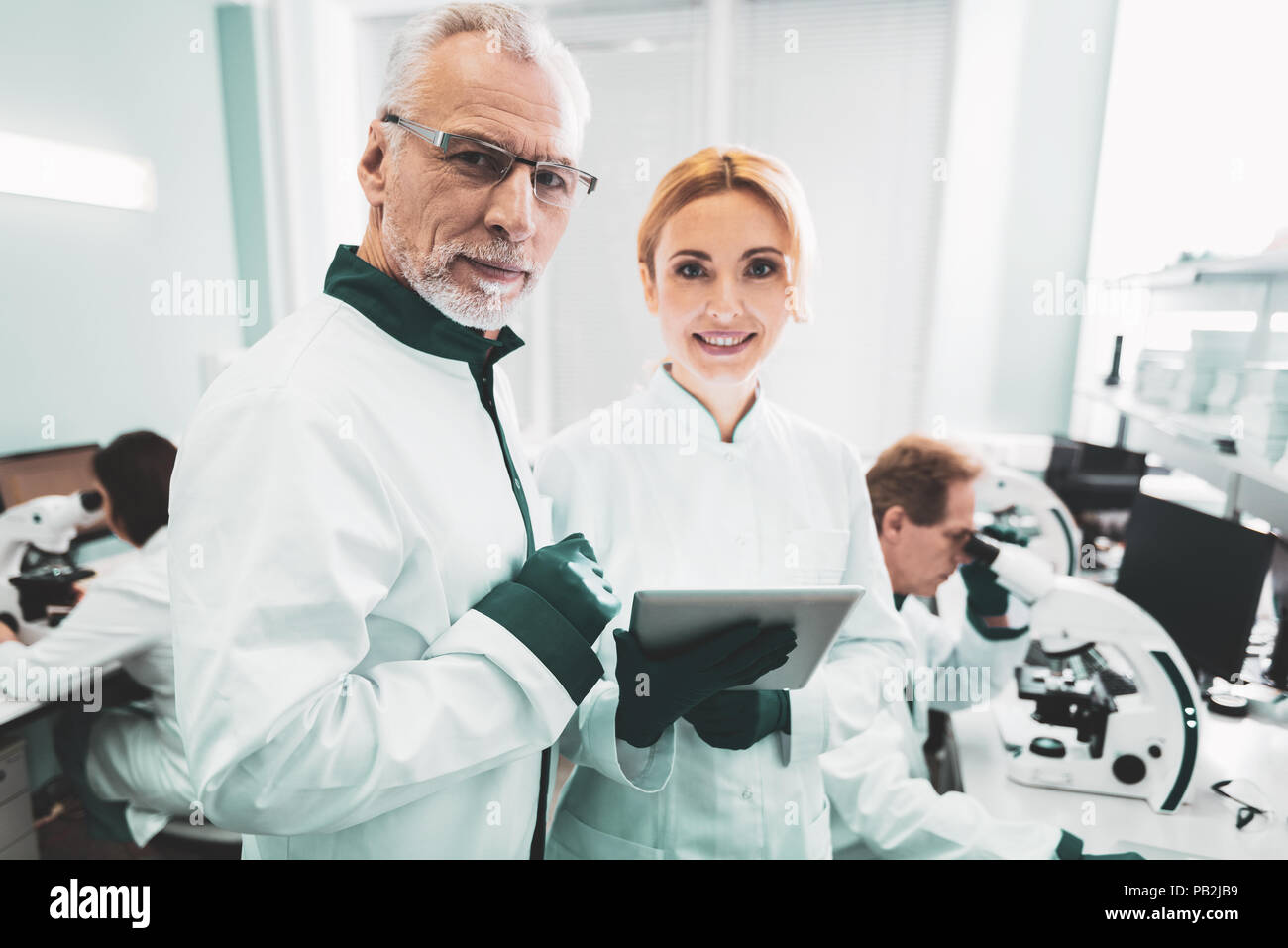 Smiling scientists enjoying working process in laboratory Stock Photo ...