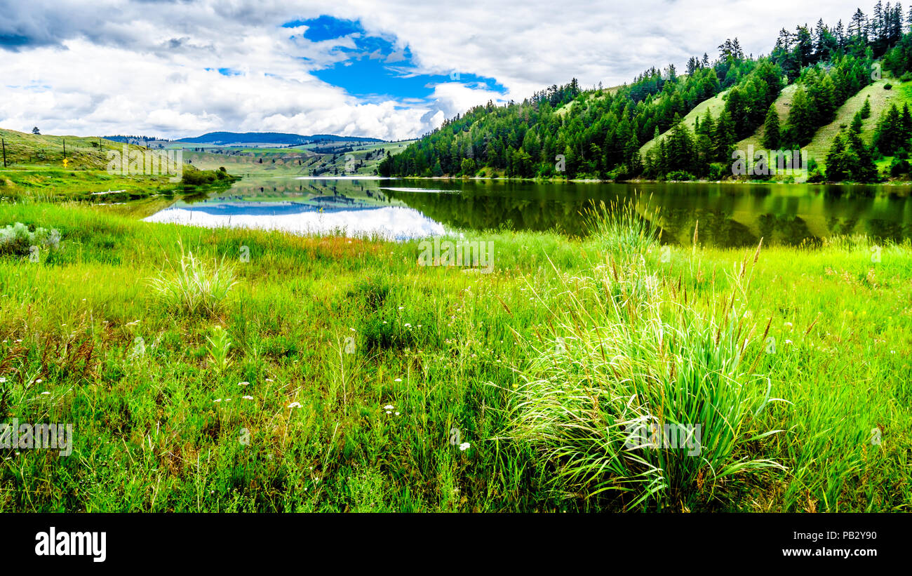 Blue Sky, Clouds and surrounding Mountains reflecting in the water of ...