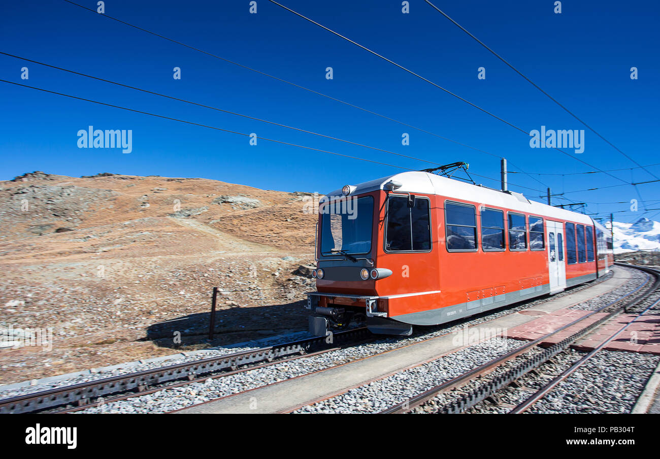 red tram or train on rail transportation to Matterhorn, popula Alps ...