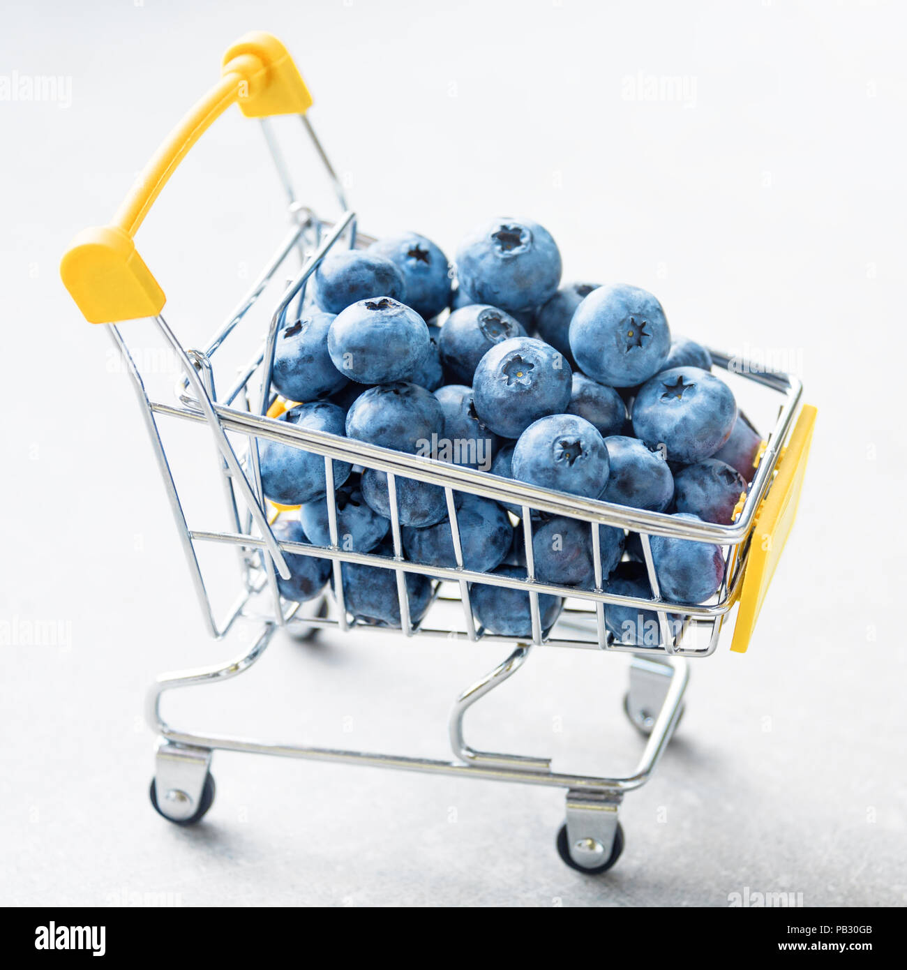 Blueberry fruits in mini shopping cart. Selective focus on the ...