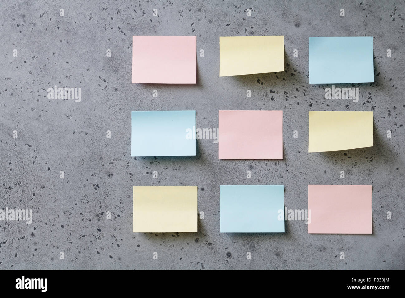 Colorful empty sticky notes on a grey textured background. The concept ...