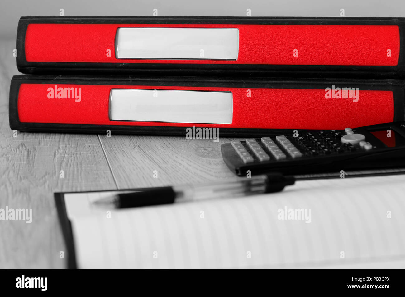 Red folders with blank labels on the spine on a desk with selective ...