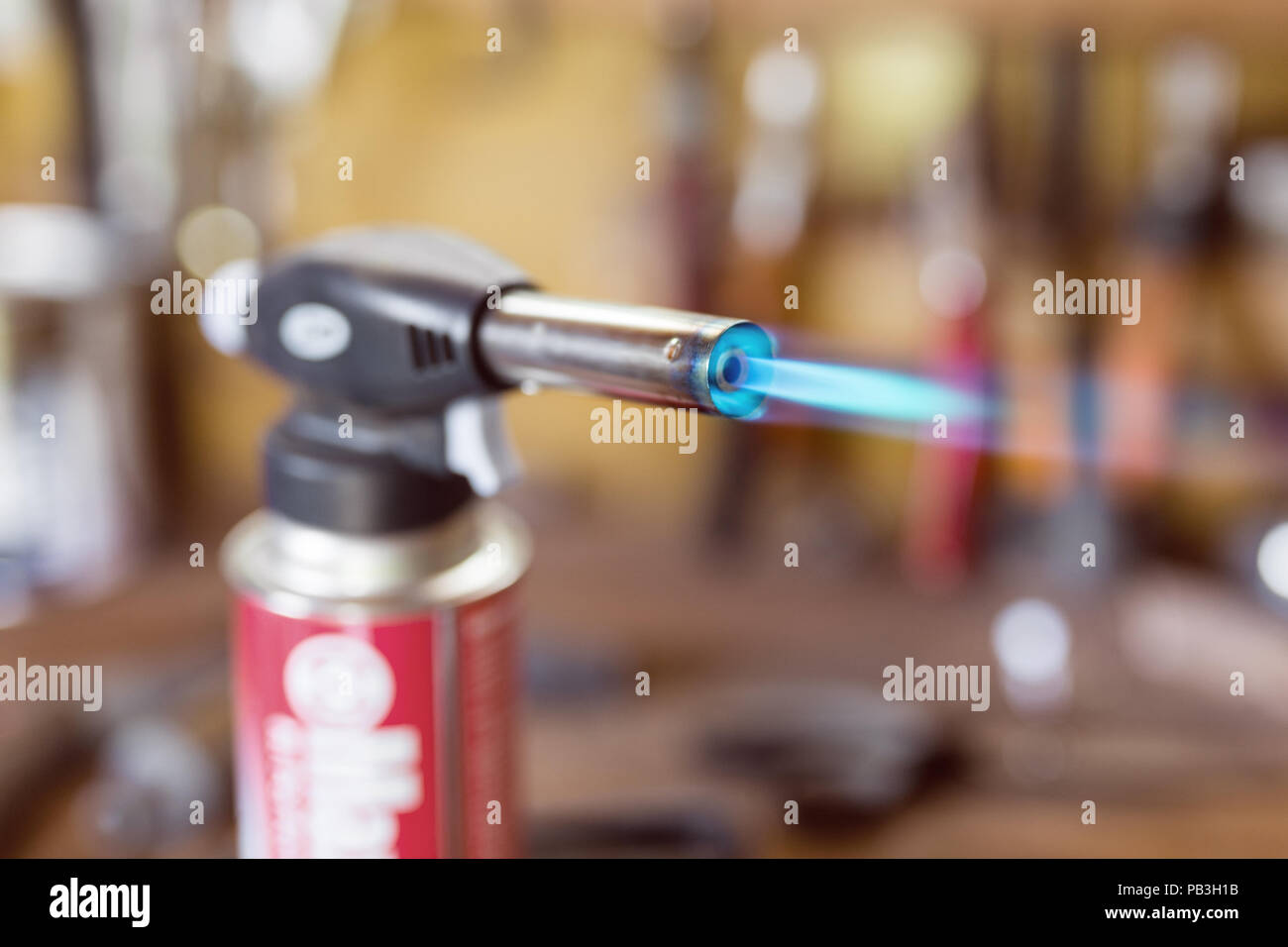 Gas cartridge gun lighter .Close-up nozzle of burner with blue flame ...