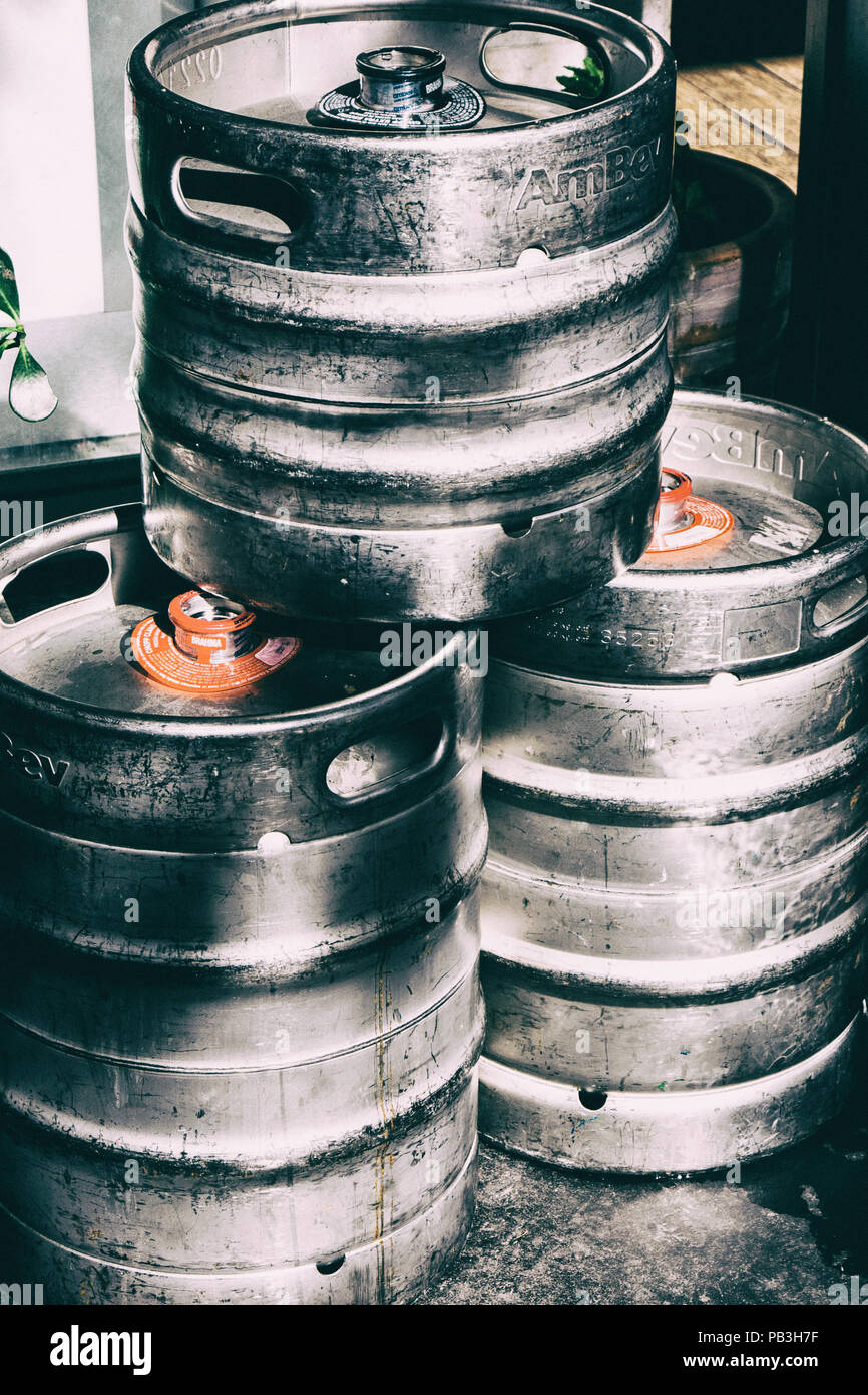 Used metallic beer barrels in the street in front of a pub. No people ...