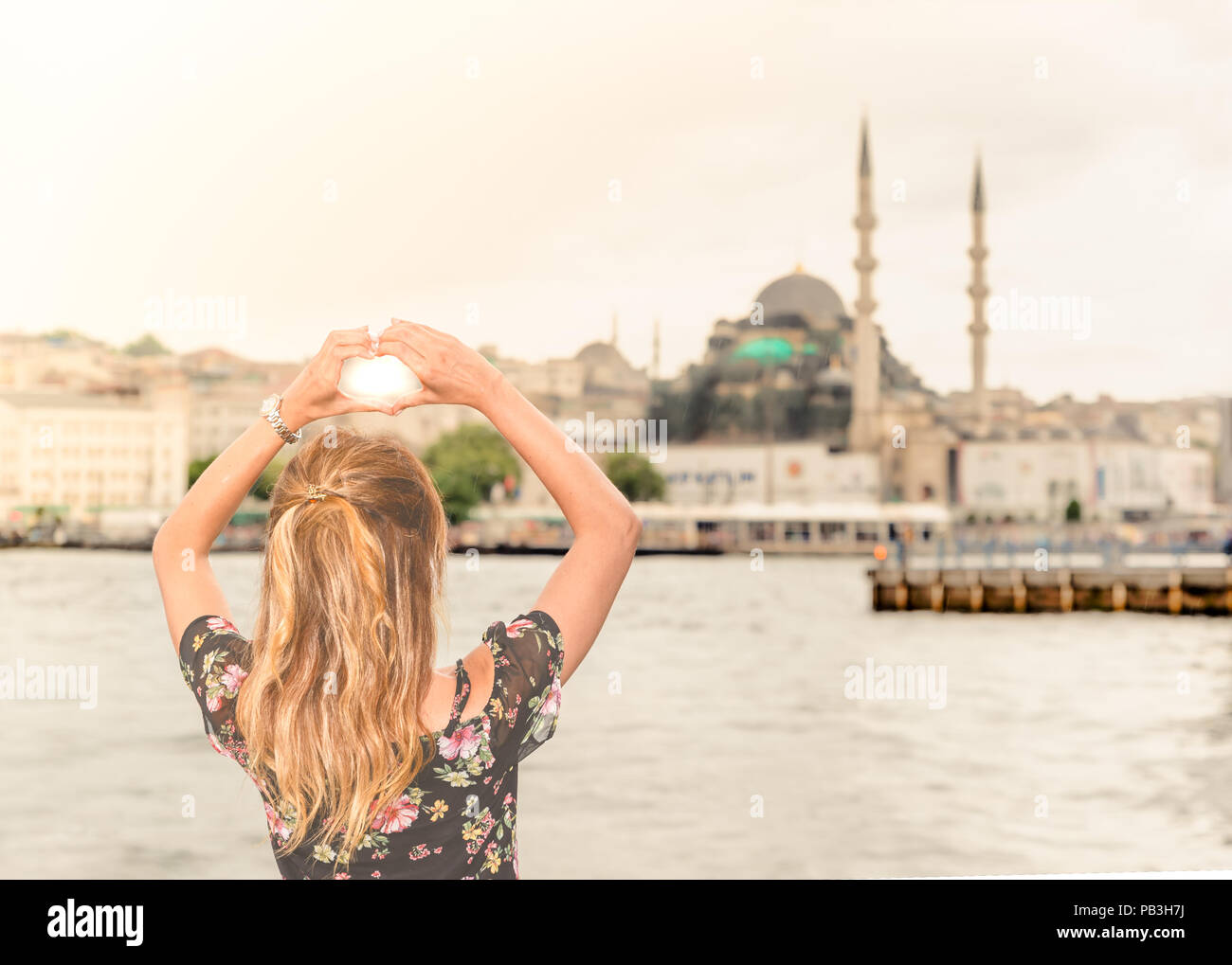 Beautiful woman traveler makes heart shape with hands on view of New ...