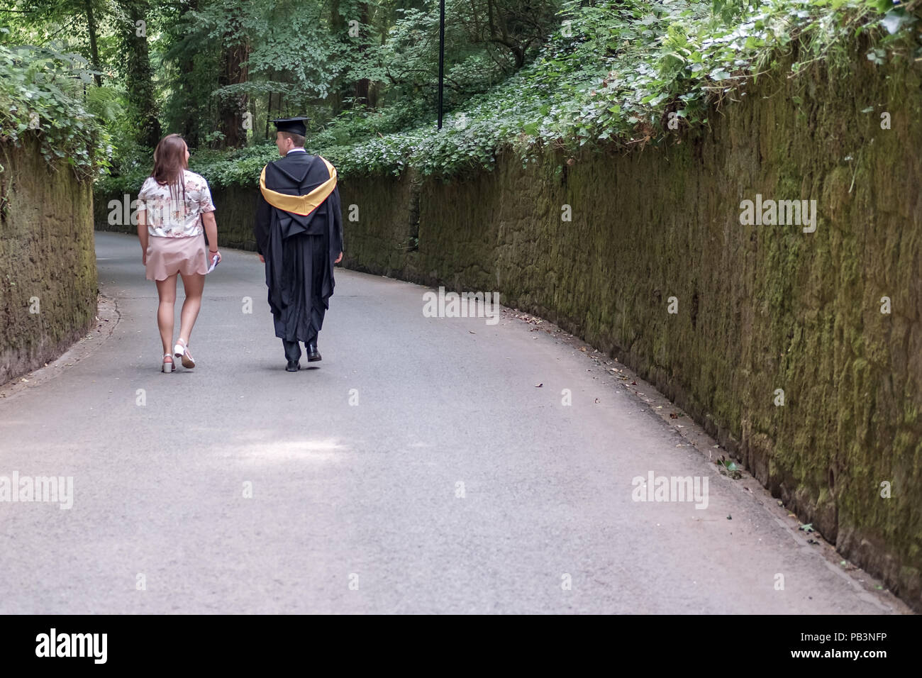 Young college couple seen walking down a campus path, following the ...
