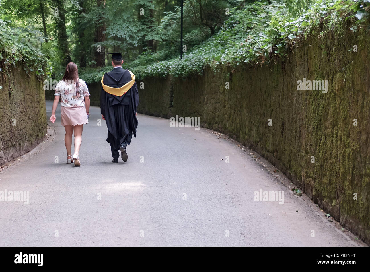 Young college couple seen walking down a campus path, following the ...