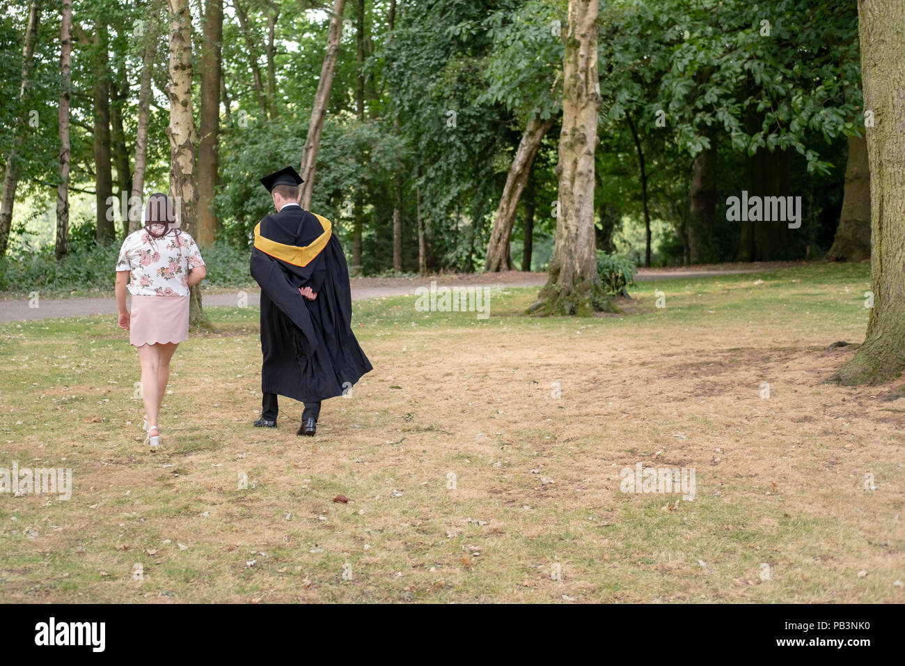 Young college couple seen walking down a campus path, following the ...