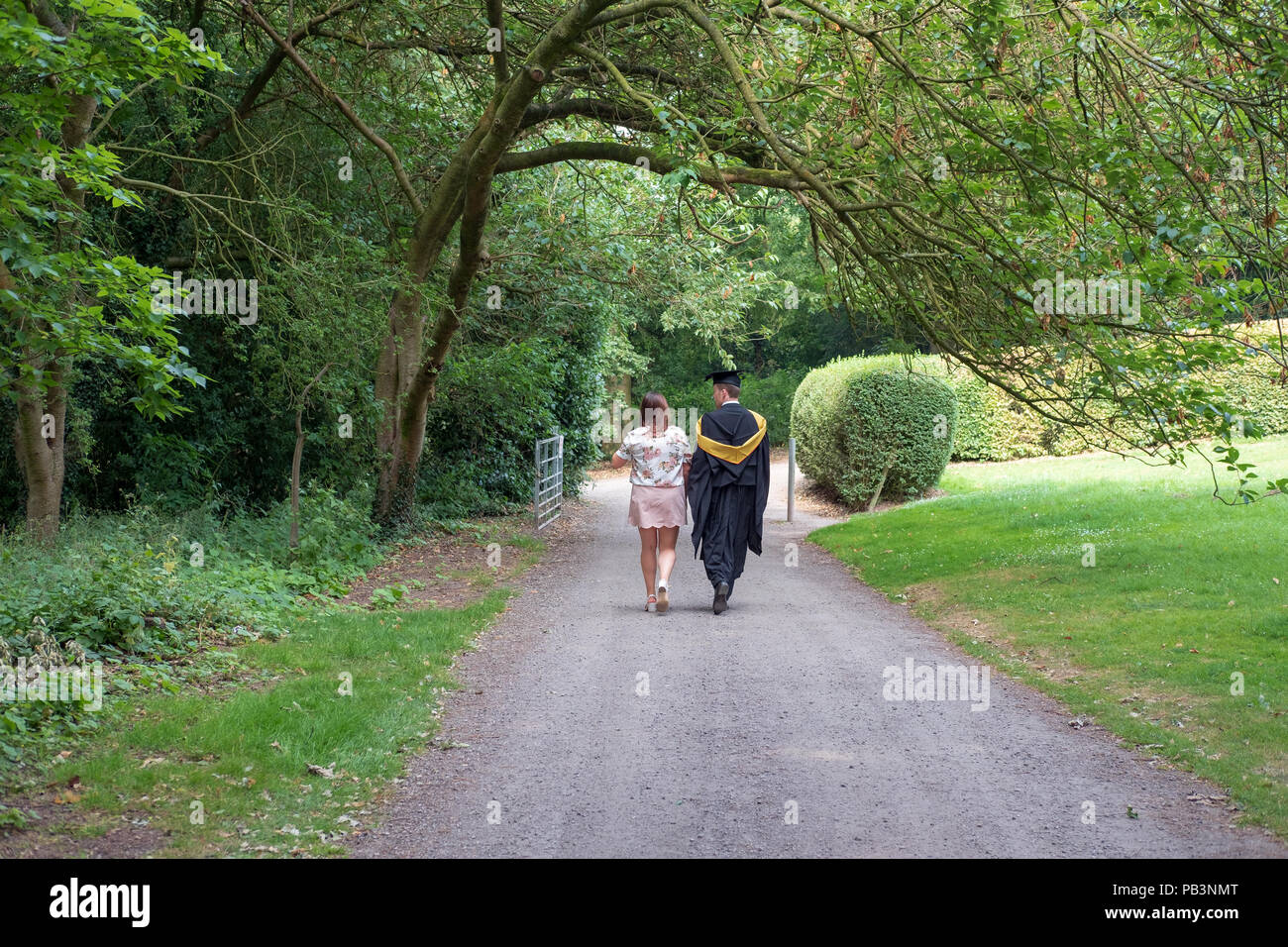 Young college couple seen walking down a campus path, following the ...