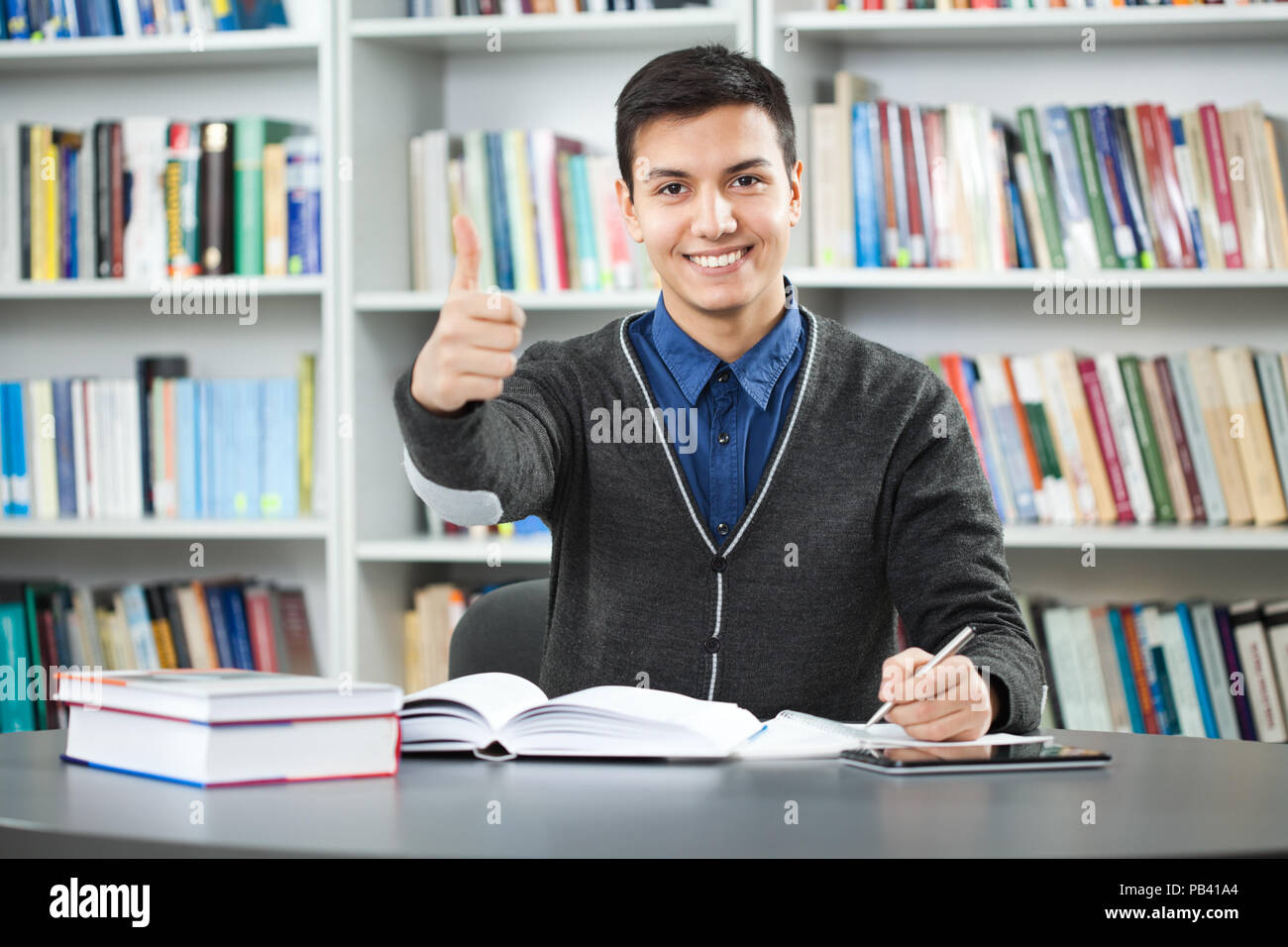 Happy student is learning in library Stock Photo - Alamy