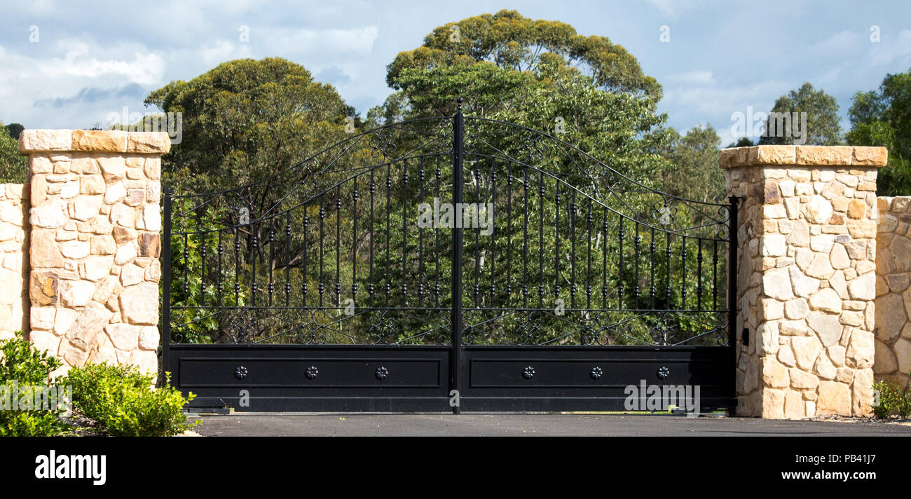 Metal driveway rural property entrance gates set in sandstone brick ...
