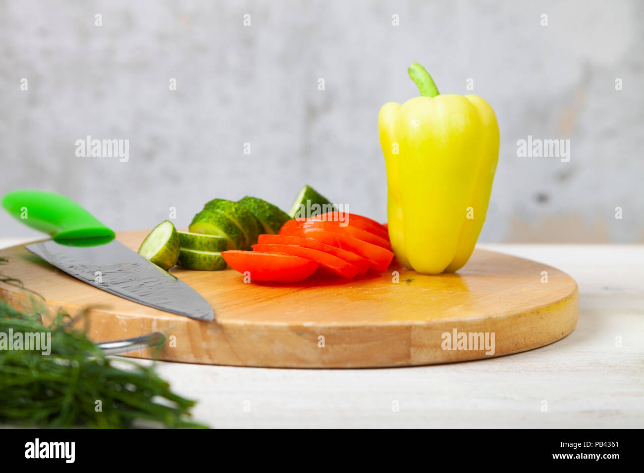 Vegetables for salad, knife and cutting board on the table. Preparation ...