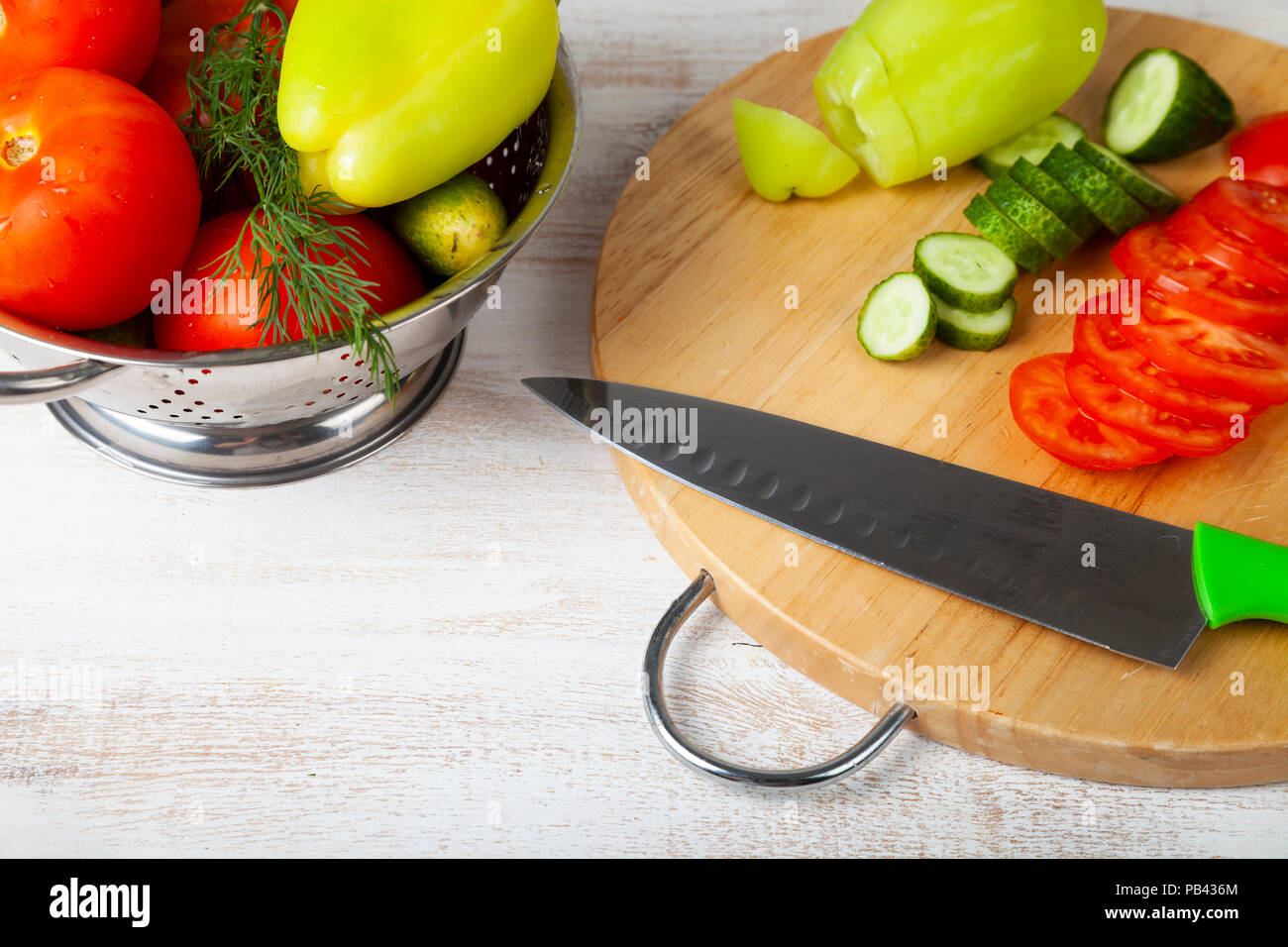 Vegetables for salad, knife and cutting board on the table. Preparation ...
