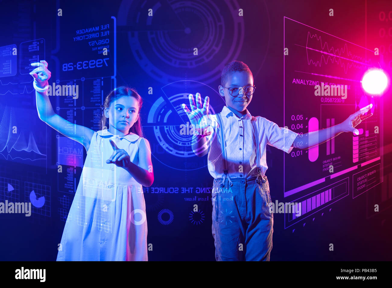 Clever kids using futuristic devices while studying Stock Photo - Alamy
