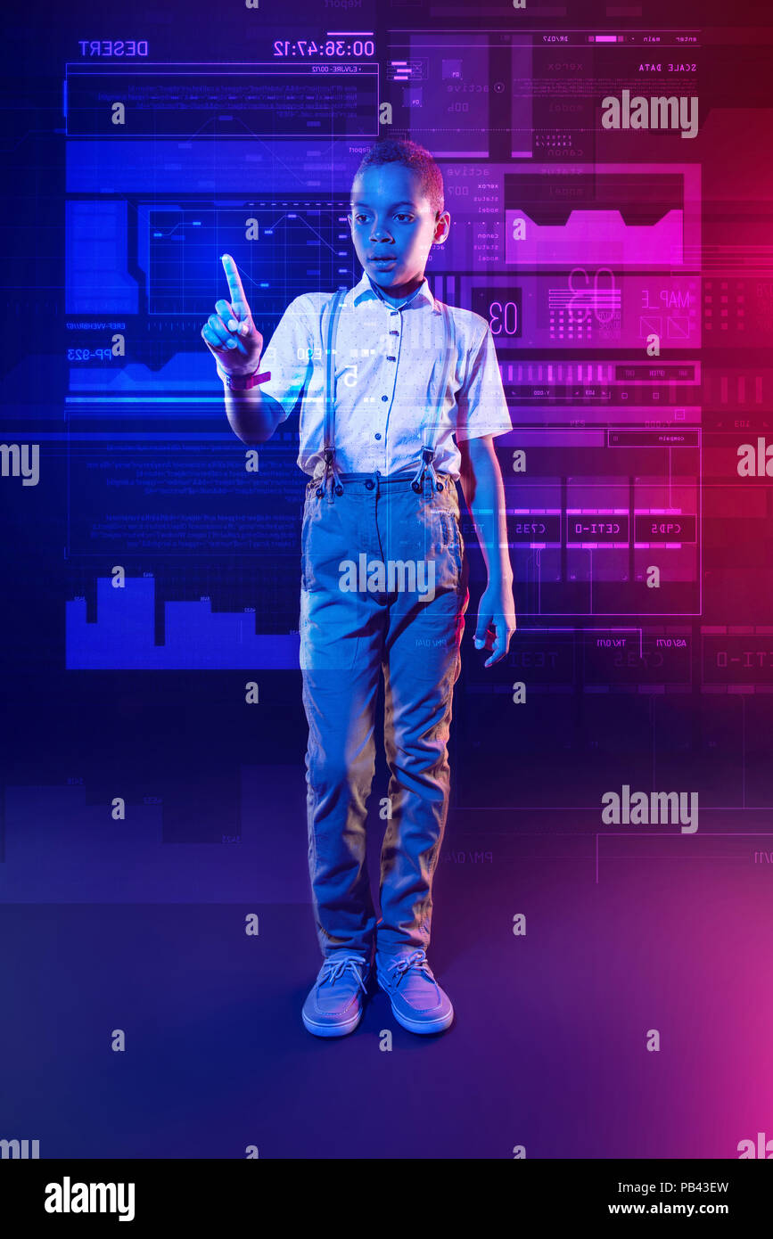 Serious boy pointing to the screen and thinking Stock Photo - Alamy