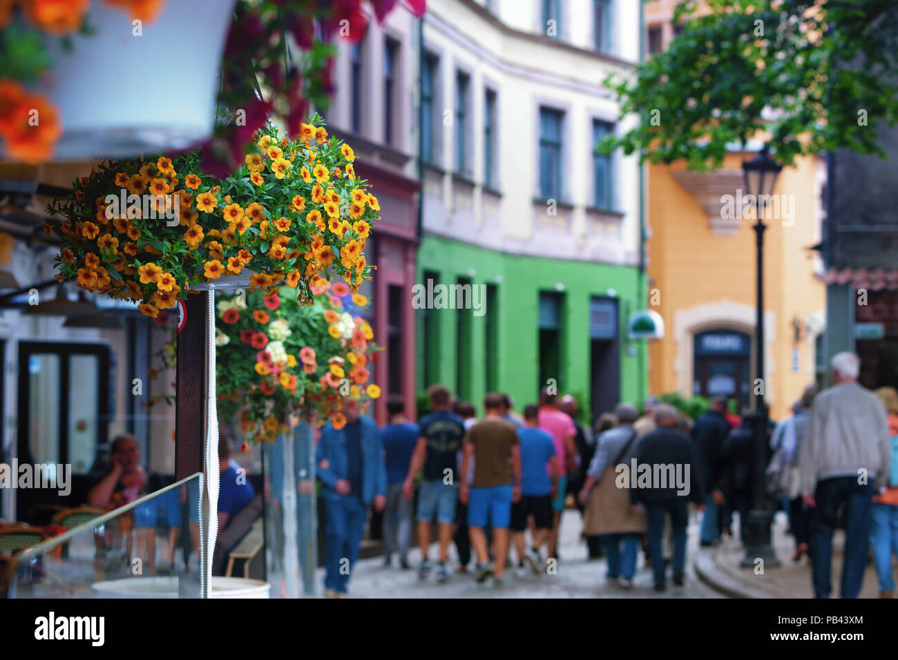 Tourists walking along the street of the old town with colorful facades ...