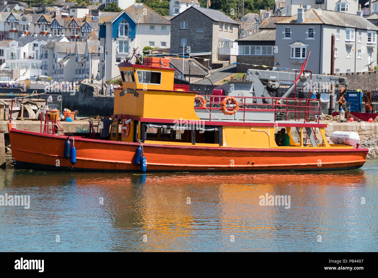 Tourist excursion boat Brixham Belle moored alongside the harbour wall ...
