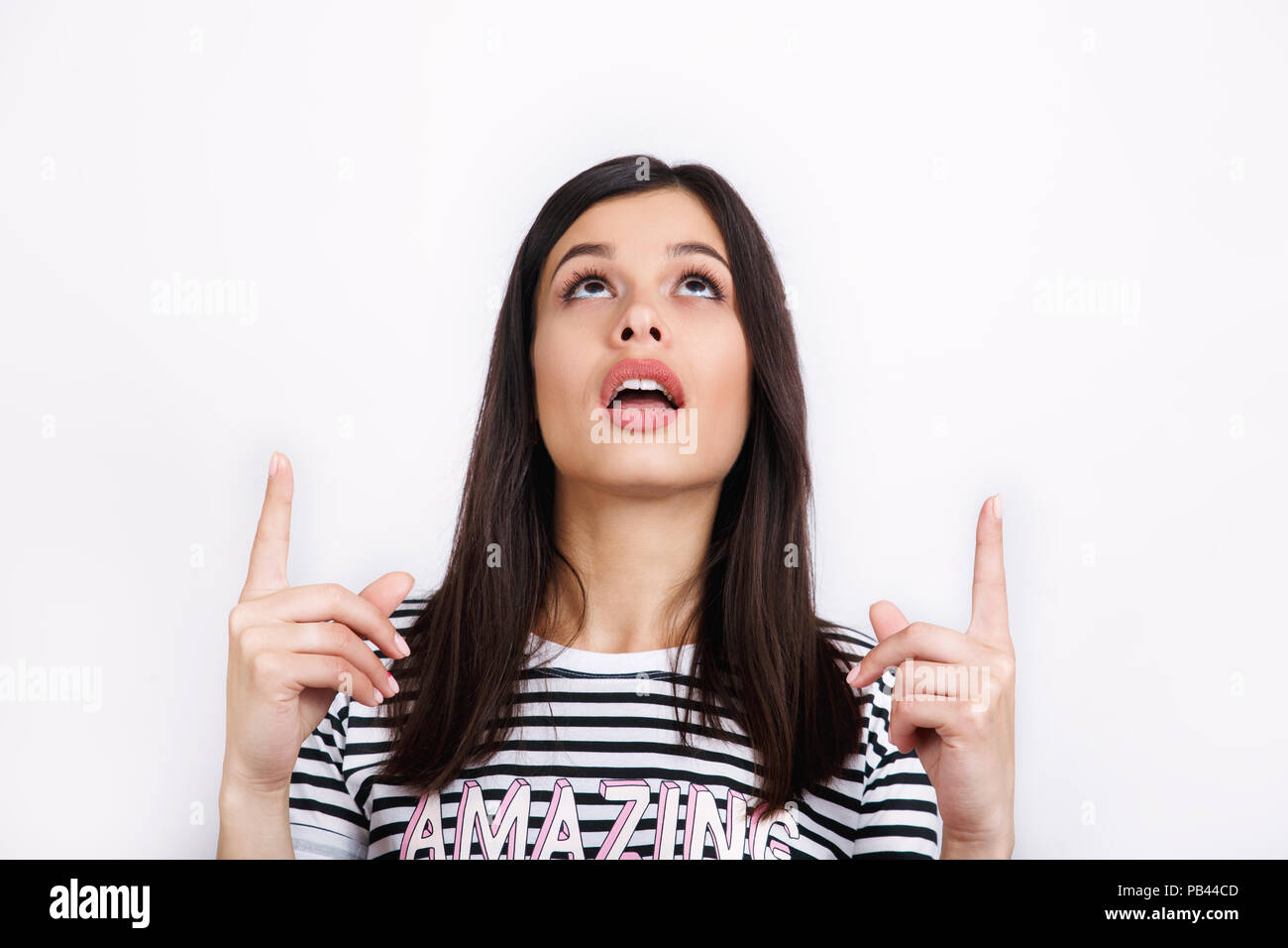 Good looking brunette female with pure healthy skin looks in amazement ...