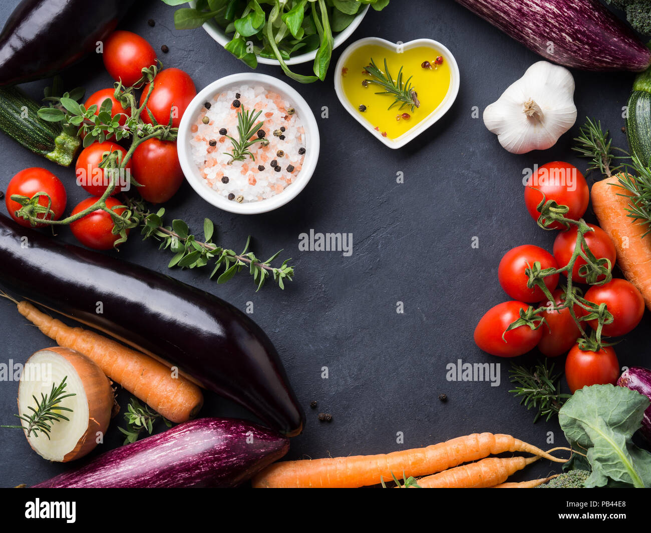 Mix of raw vegetables with salt, spices on dark background. Clean ...