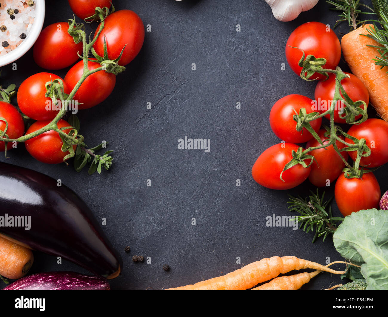 Mix of raw vegetables with salt, spices on dark background. Clean ...
