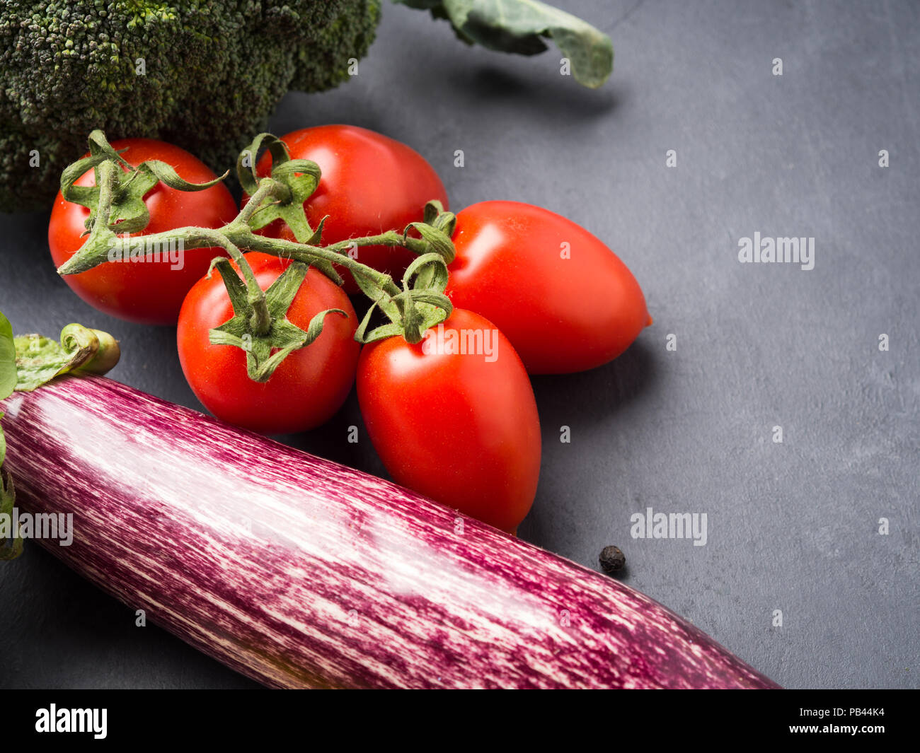 Mix of raw vegetables with salt, spices on dark background. Clean ...