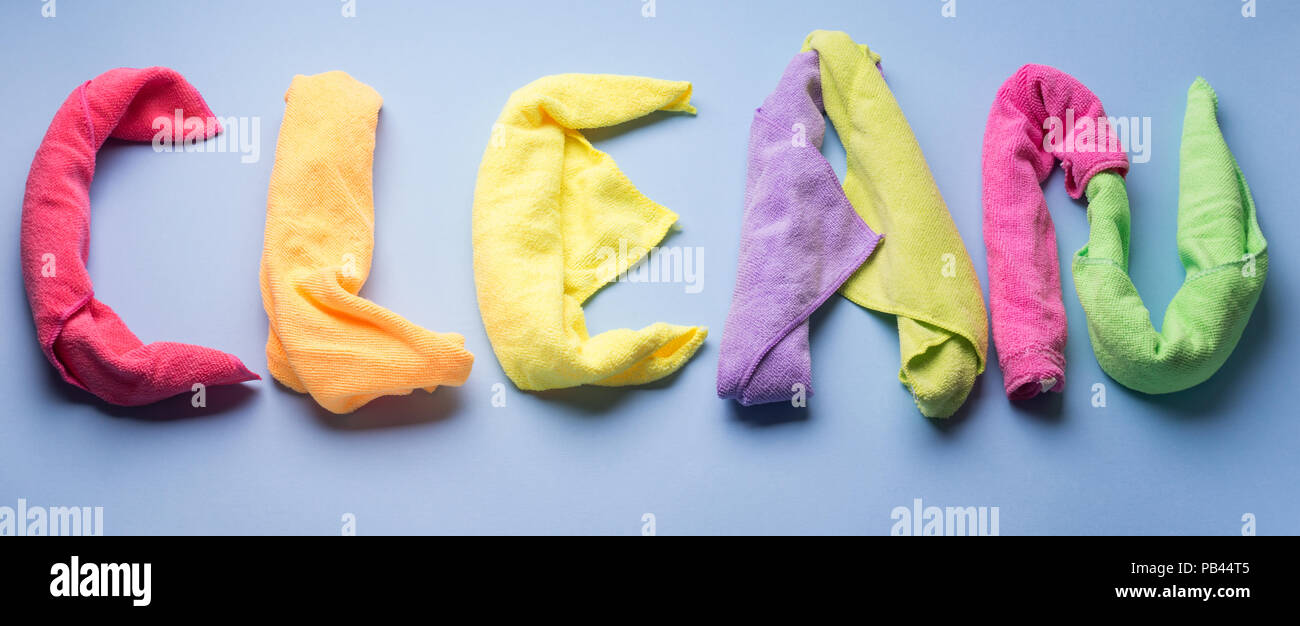 Word Clean written with cleaning cloths as letters on blue pastel ...
