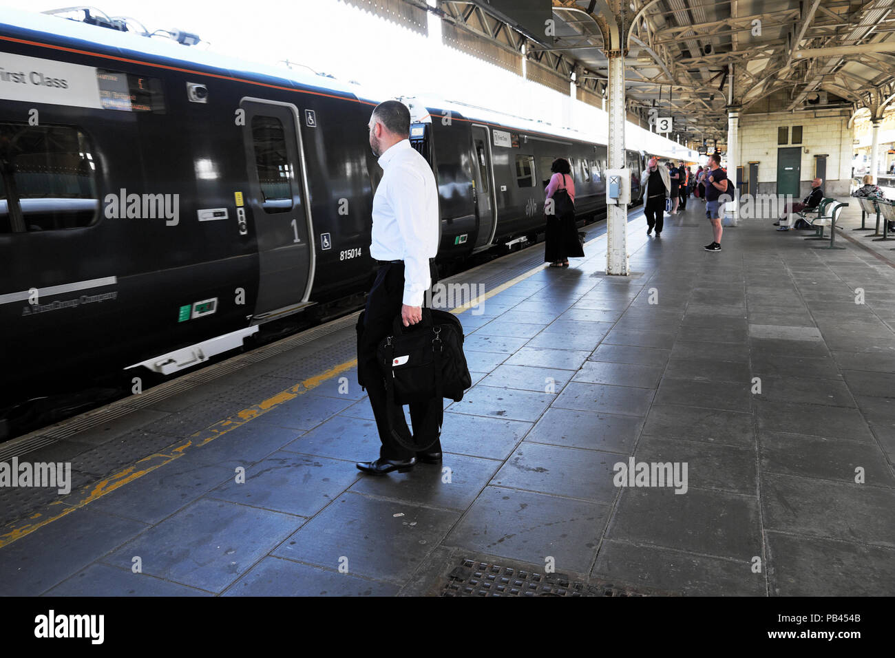 Business man standing on platform preparing to board first class ...
