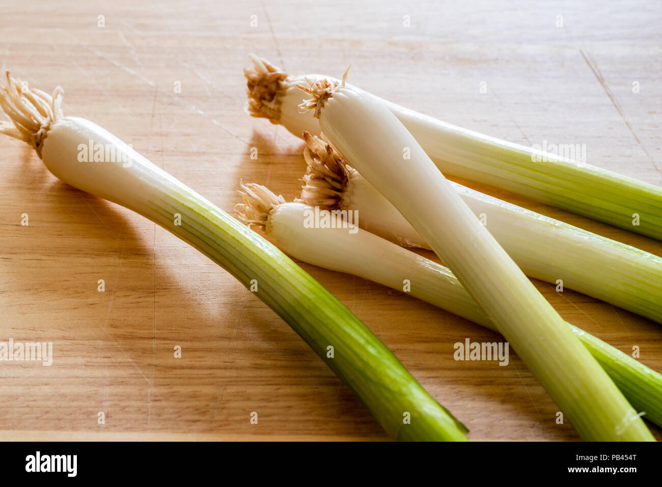 Fresh washed spring onions on a kitchen chopping board Stock Photo - Alamy