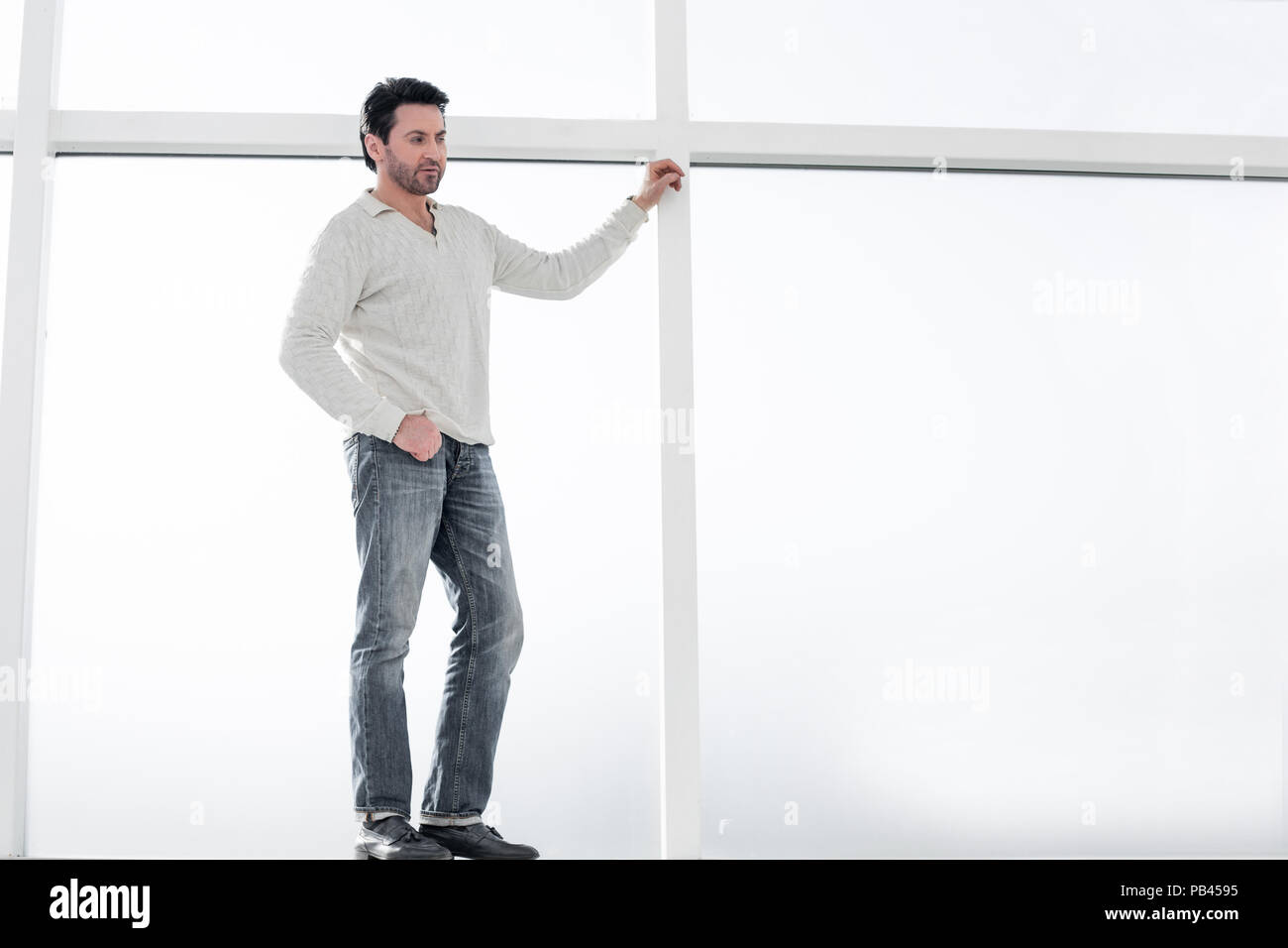 rear view.a man standing near a large window Stock Photo - Alamy