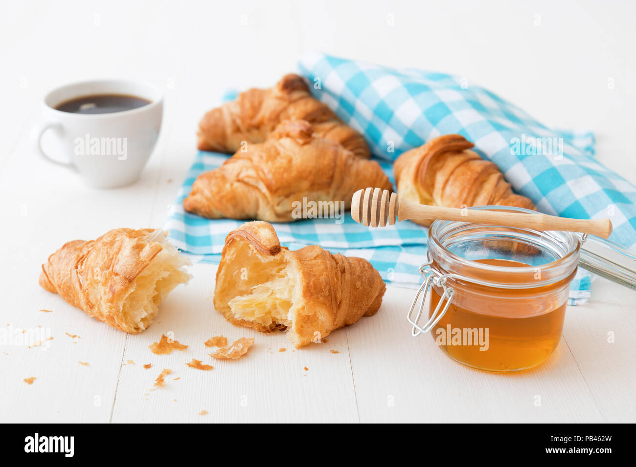 French style breakfast, a white wooden table with cup of fresh black ...