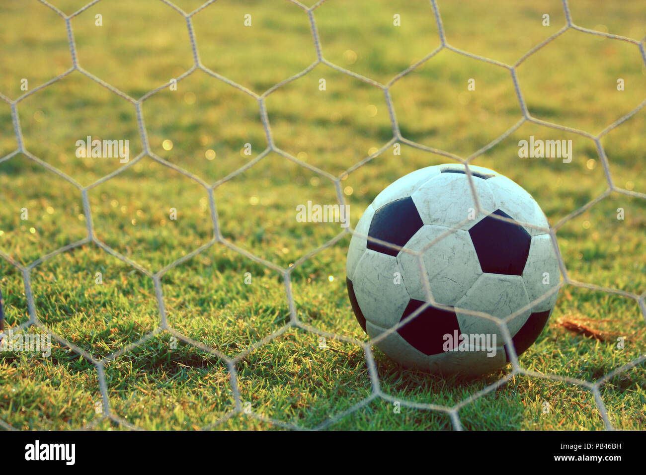 Soccer football in Goal net with green grass field - vintage effect ...