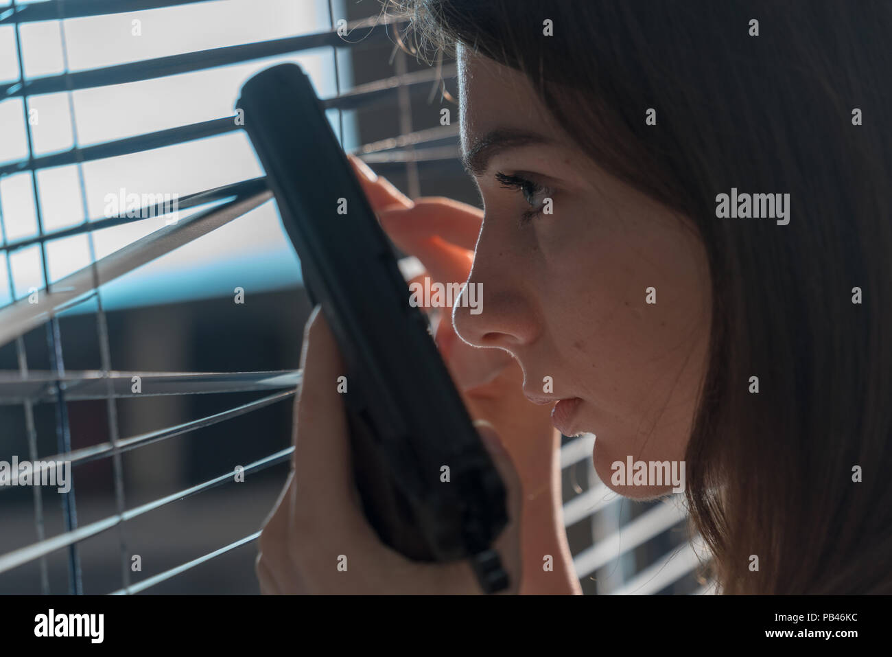 young woman with a gun at the window Stock Photo - Alamy