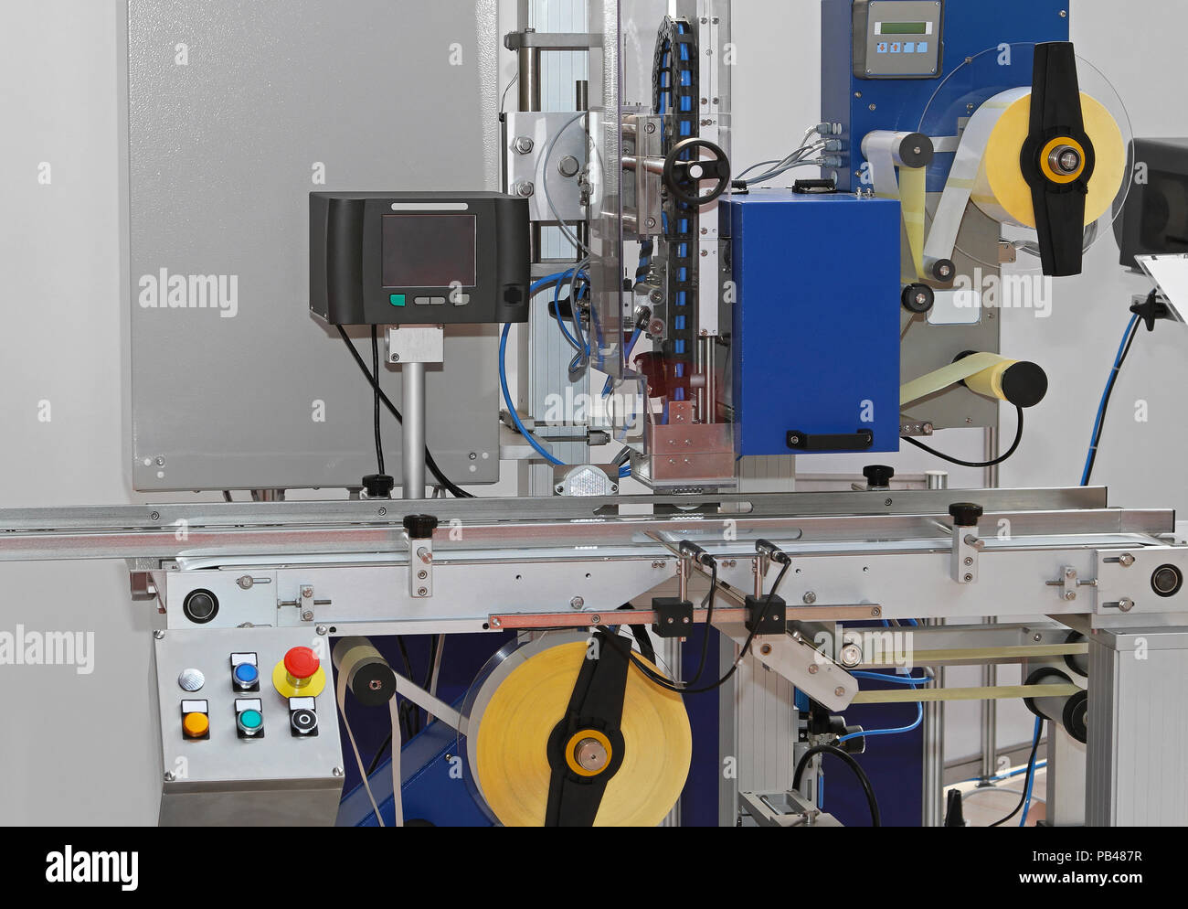 Labeling machine with conveyor belt in factory Stock Photo - Alamy