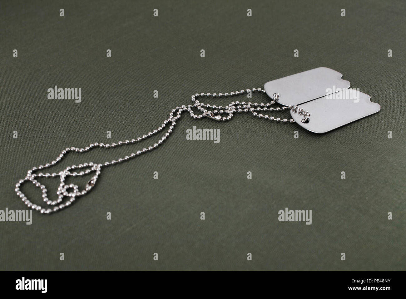 U.S. Army dog tags on olive green uniform background Stock Photo - Alamy