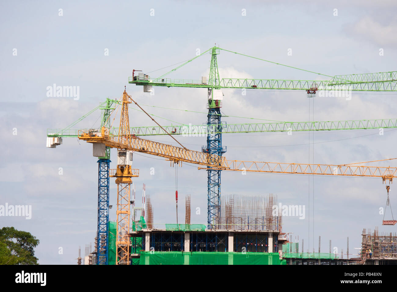 Industrial construction cranes on sky background Stock Photo - Alamy