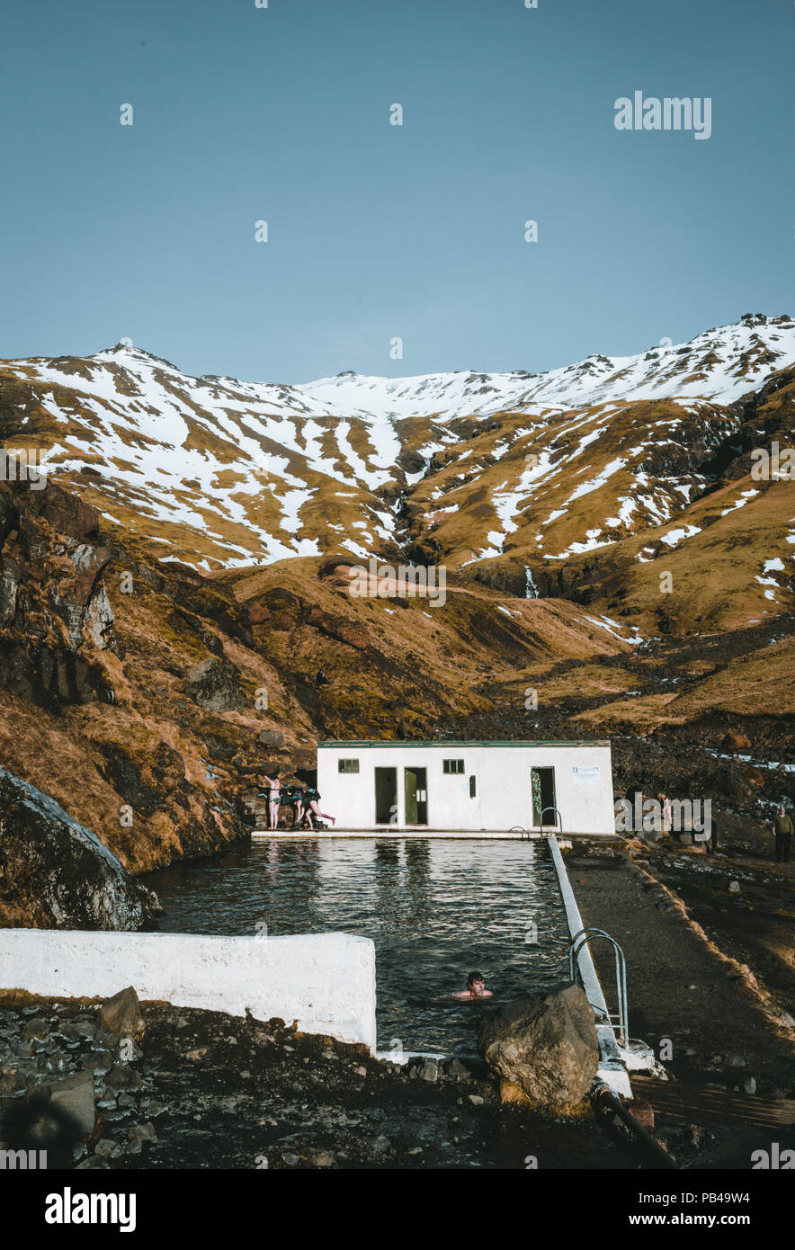 Natural swimming pool Seljavallalaug in iceland with man in water and ...